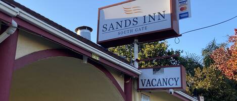 Placa de hotel com 'Sands Inn' e 'Vagas', indicando quartos disponíveis.