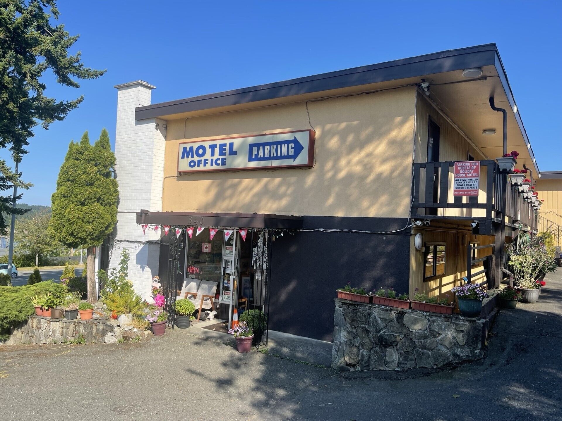 Balcão de atendimento de um motel com uma placa indicando a área de estacionamento.