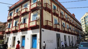 Um edifício com vários andares, varandas, uma placa com a inscrição 'MOBLIS' e uma porta azul.