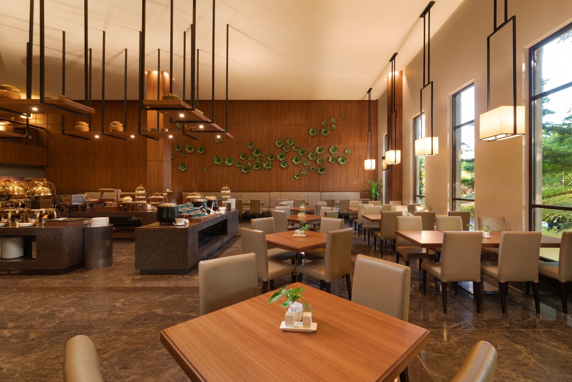 Restaurante moderno com pé direito alto, iluminação pendente e área central de atendimento.