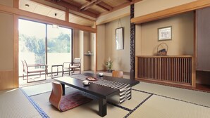 Um quarto japonês tradicional, com tatames, uma mesa baixa e portas deslizantes que dão para uma varanda.