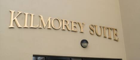 Um edifício com uma placa que diz "Kilmorey Suite".