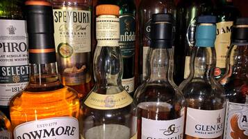 Diversas garrafas de whisky escocês single malt expostas numa prateleira.