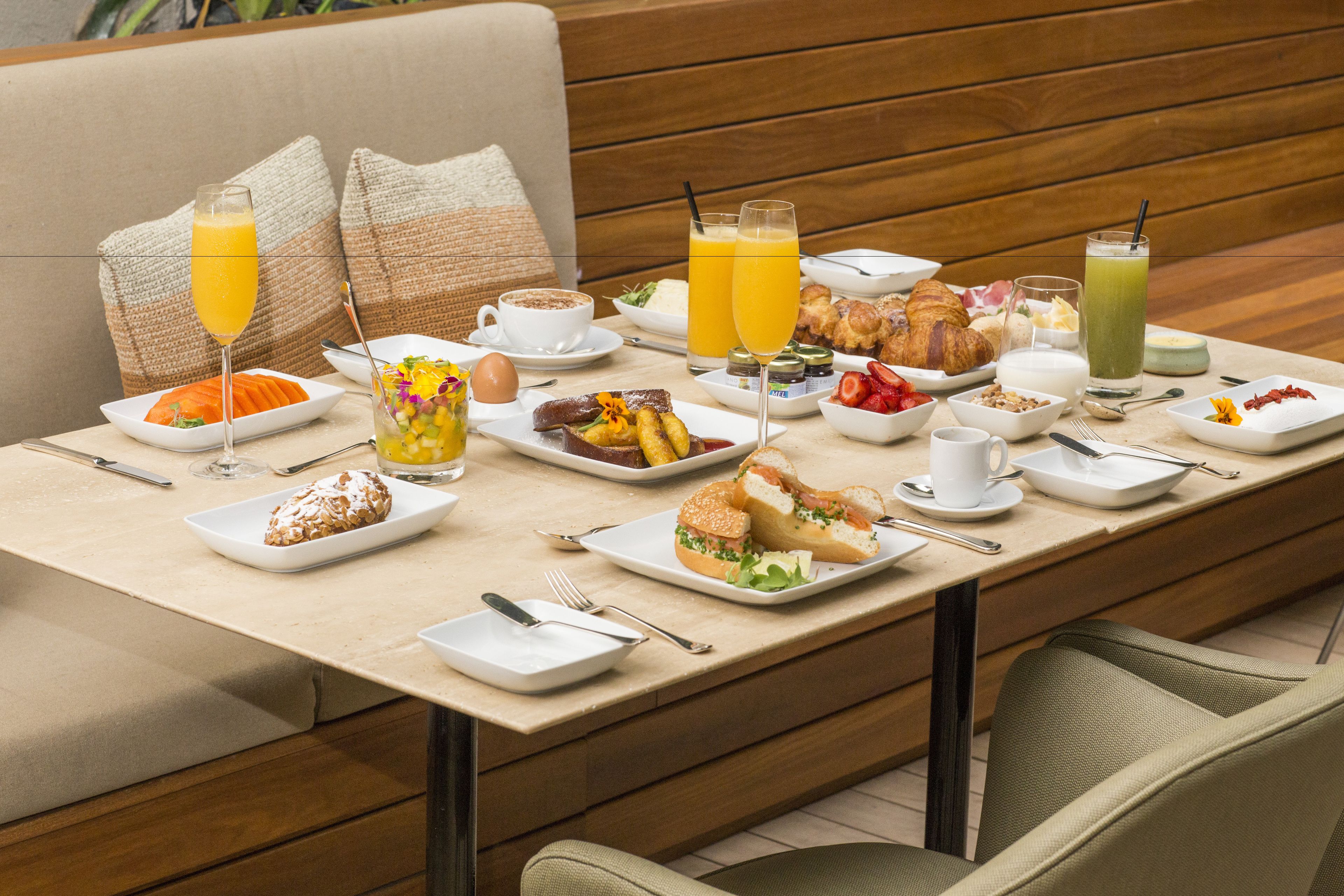 Um buffet de café da manhã com diversos pratos e bebidas sobre uma mesa em um ambiente acolhedor.