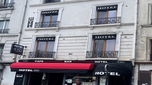 Um hotel com várias varandas, um café e um bar no andar térreo.