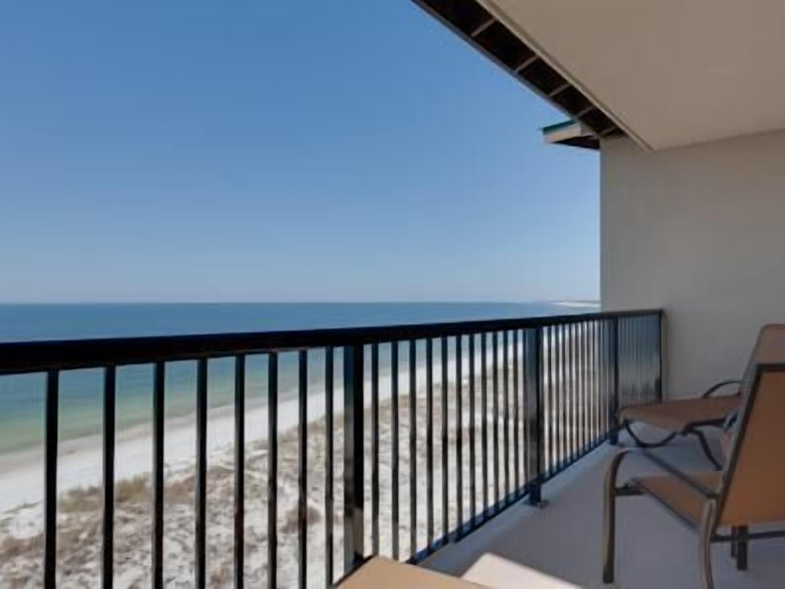 Uma varanda com vista para a praia e o oceano.