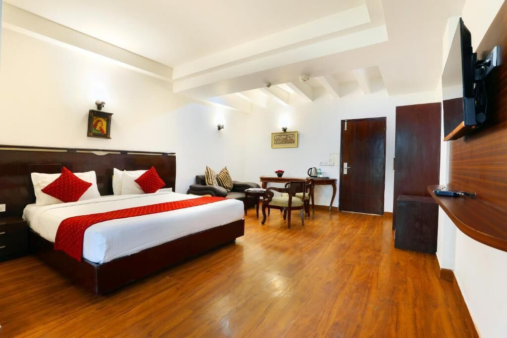 Quarto de hotel com uma cama grande, uma escrivaninha e uma cadeira.