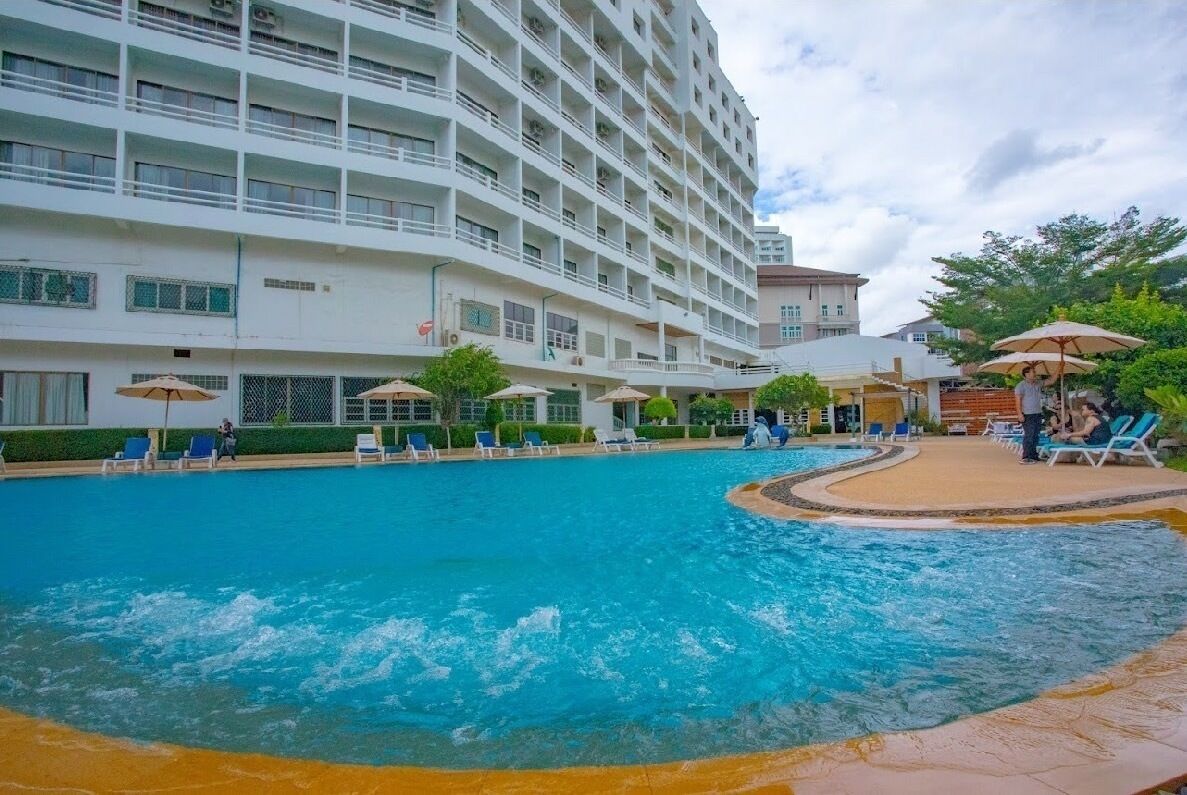 Um hotel com piscina, várias varandas e áreas de estar ao ar livre.