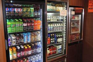 Máquina de vendas abastecida com diversas bebidas, incluindo refrigerantes, sucos e bebidas alcoólicas.