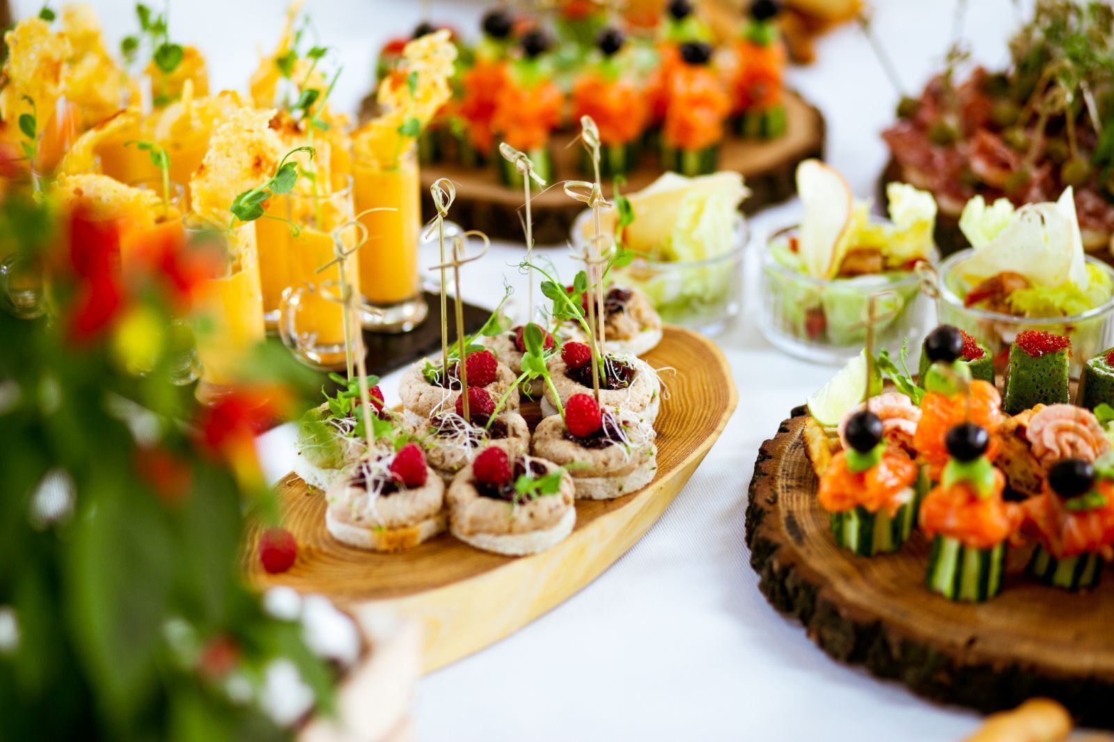 Diversas opções de comida e bebida em uma mesa, incluindo petiscos, saladas e bebidas.