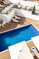 Piscina no terraço com espreguiçadeiras e guarda-sóis.