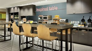 Cozinha moderna com balcão, banquetas e um letreiro com a inscrição 'inspired table'.