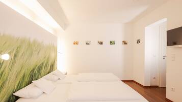 Quarto moderno com uma cama grande, uma obra de arte na parede e uma porta para o banheiro.