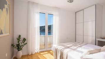 Quarto com cama, planta em vaso, porta de correr com vidro para uma varanda e vista para um corpo de água.