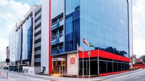 Um edifício moderno com fachada de vidro e esquema de cores vermelho e branco.