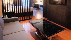 Quarto de hotel moderno com uma cama grande, uma escrivaninha e um espaço para refeições.