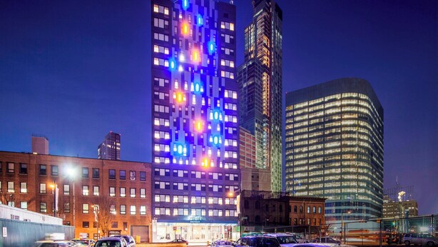 Hotel com design moderno, destacando uma fachada iluminada e estrutura curvilínea.