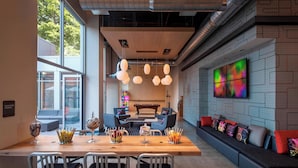 Um interior moderno com mesa de jantar de madeira, cadeiras, sofá com almofadas e mesa de bilhar.