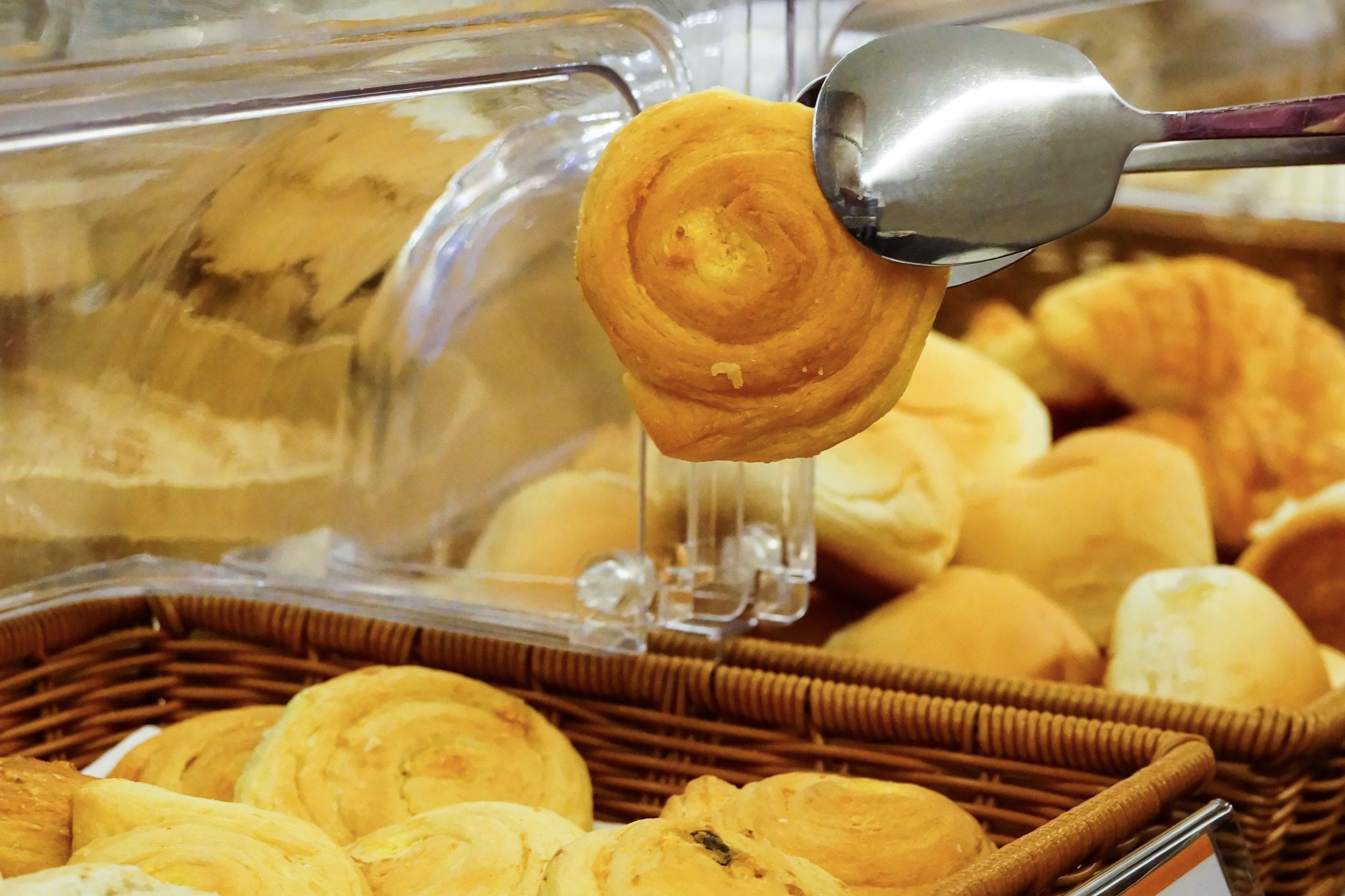 Um buffet com uma variedade de pastelaria, incluindo croissants e outros produtos de panificação.