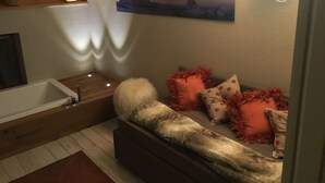 Uma casa de banho moderna com toucador de madeira, uma banheira e um espelho grande.
