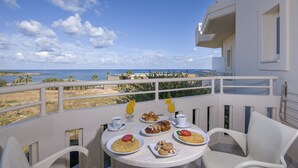 Varanda com mesa posta para o café da manhã, com vista para a costa.