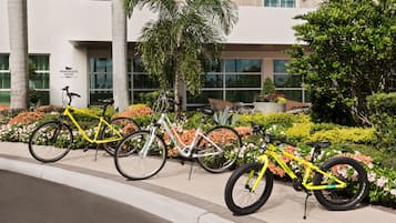 Hotel com espaço para bicicletas, área de estar ao ar livre e paisagismo exuberante.