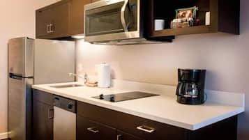 Um frigorífico/congelador grande, um micro-ondas, uma placa de cozinha