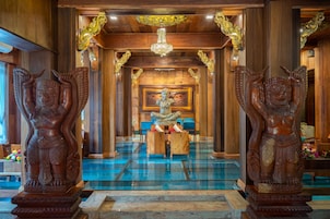Interior tradicional em madeira com uma estátua central, piso azulejado em azul e decorações douradas elaboradas.