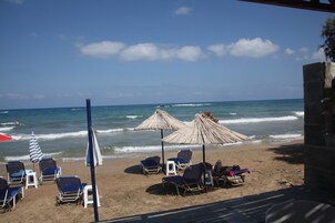 Perto da praia, espreguiçadeiras, guarda-sóis, bar na praia 
