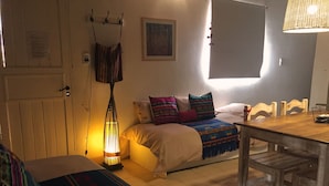 Um quarto aconchegante com uma cama, mesa de cabeceira, abajur e janela.