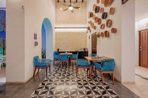 Um restaurante com cadeiras azuis, chão estampado e cestos de vime na parede.