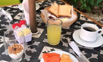 Uma mesa estampada com torradas, fruta, um copo de suco e uma xícara de café para o café da manhã.