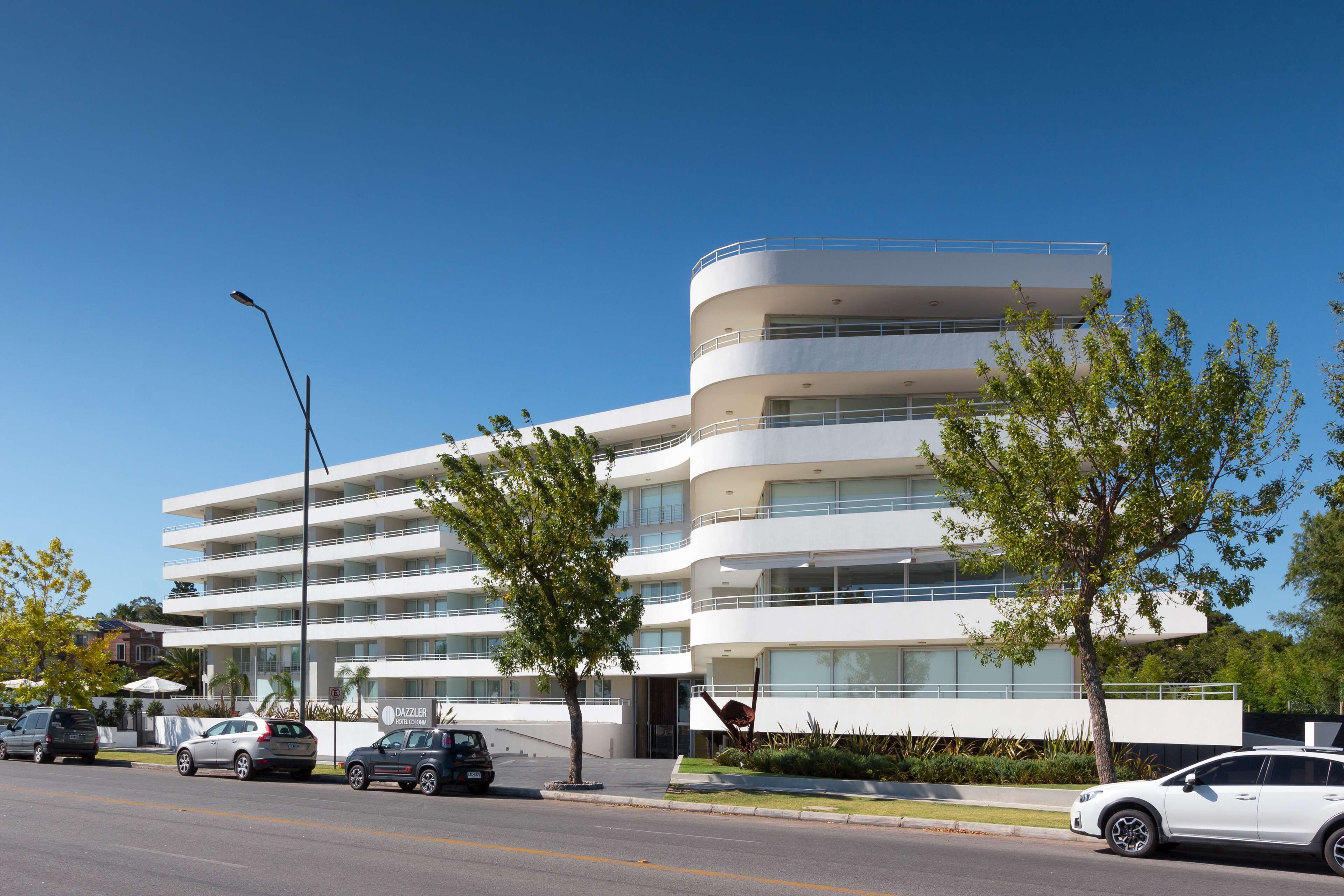 Um edifício de vários andares com design arquitetônico moderno, com varandas e grandes janelas.