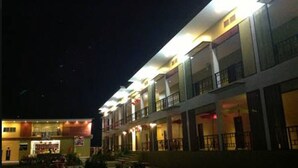 Hotel com vários andares, varandas e fachada bem iluminada.