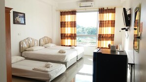Quarto de hotel com duas camas, uma mesa e uma televisão.