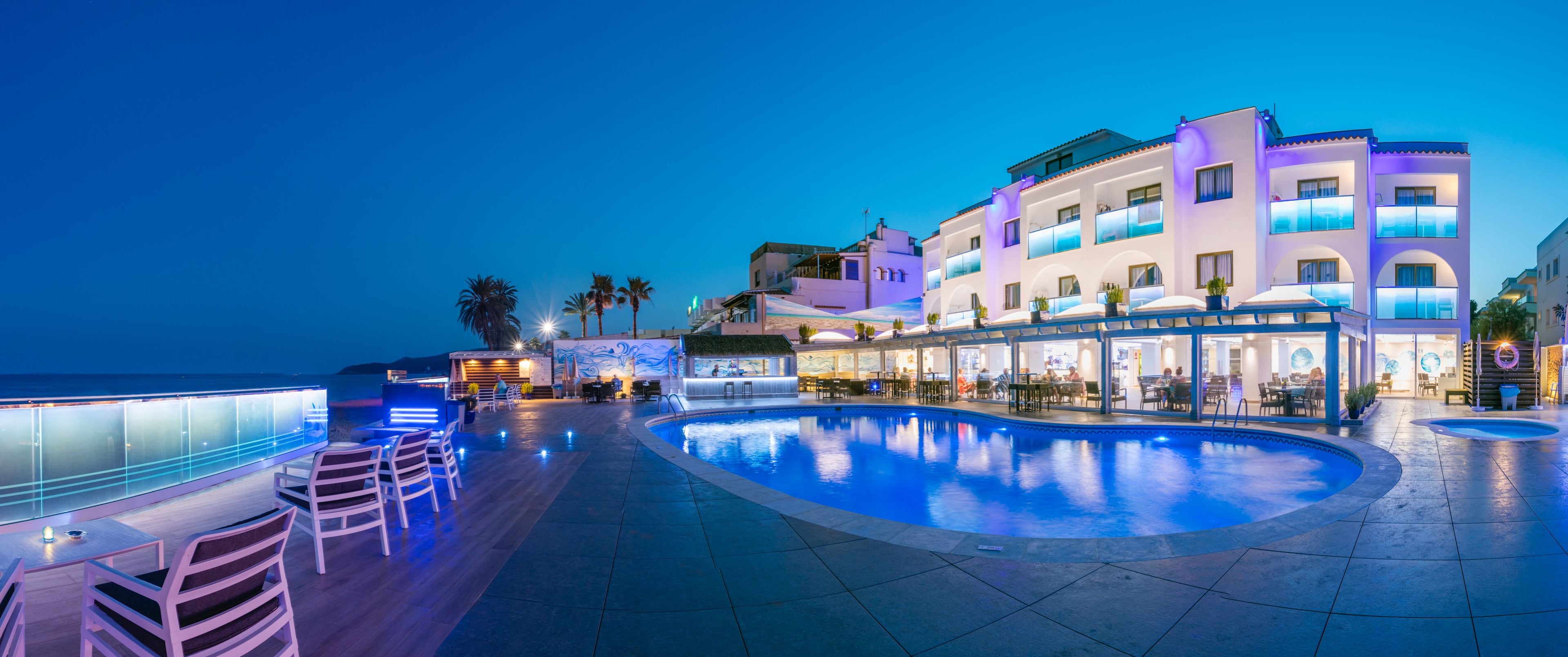 Um hotel com piscina, área de estar ao ar livre e bar.