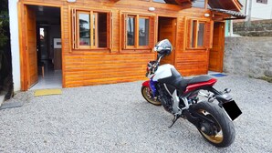 Uma casa de madeira com uma motocicleta estacionada na frente.