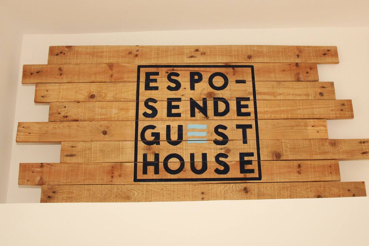 Uma placa de madeira com o texto 'ESPO-SENDE GUEST HOUSE'.