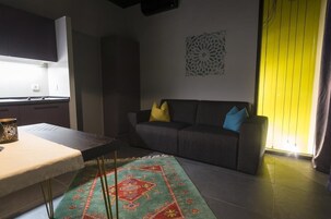 Uma sala de estar moderna com um sofá, uma mesa de centro e um tapete estampado.