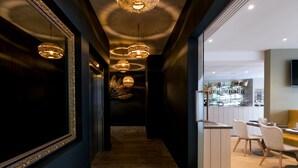 Interior moderno com um corredor escuro que leva a um espaço de bar.