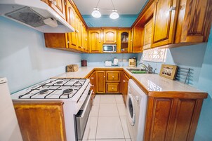 Suite Signature, várias camas, pátio, vista para o jardim | Cozinha privada | Um frigorífico/congelador grande, um micro-ondas, um forno 