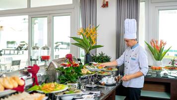 Disposição de buffet com diversos alimentos e um chef a servir.
