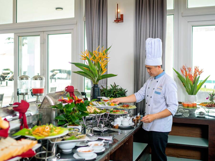 Disposição de buffet com diversos alimentos e um chef a servir.
