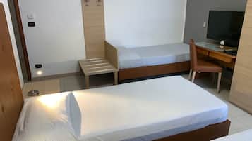 Quarto de hotel com duas camas de solteiro, uma escrivaninha com cadeira, televisão e guarda-roupa de madeira.
