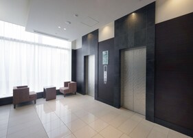 Um hall moderno com balcão de recepção, área de estar e elevador.