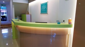 Uma mesa de recepção de hotel com uma placa que diz 'JSIA HOTEL'.