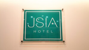 Um letreiro emoldurado com o texto "JSIA HOTEL" e estrelas decorativas.
