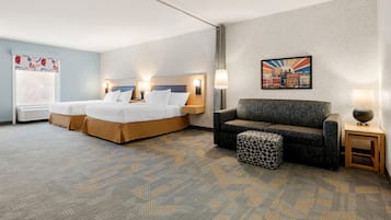 Quarto de hotel com cama, sofá, carpete estampado e pintura de paisagem urbana na parede.