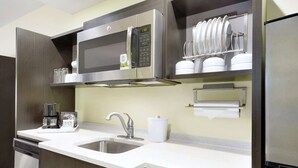 Cozinha moderna com eletrodomésticos de aço inoxidável, uma pia dupla e escorredores de louça.