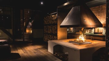 Uma cozinha moderna com lareira a lenha, parede de tijolos e um espaço de estar acolhedor.